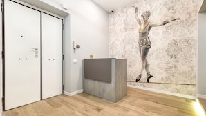 Quarto com piso de madeira, porta branca e parede com um mural de uma bailarina.