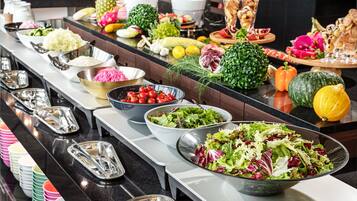Buffet com diversos pratos e saladeiras.