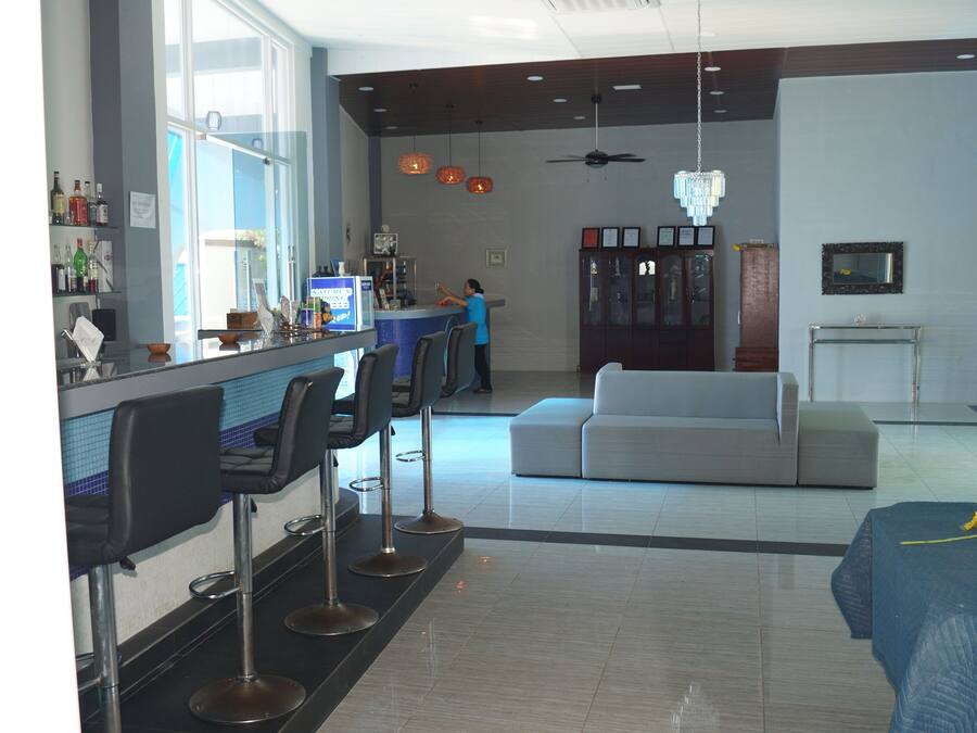 Cozinha moderna com área de bar, espaço de estar com sofá e mesa de jantar.