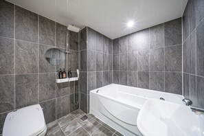 Quarto Deluxe | Casa de banho | Um polibã e uma banheira separados, artigos de higiene pessoal grátis 