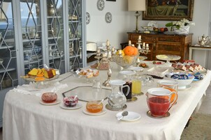 Buffet de café da manhã com diversos alimentos e bebidas em uma mesa.