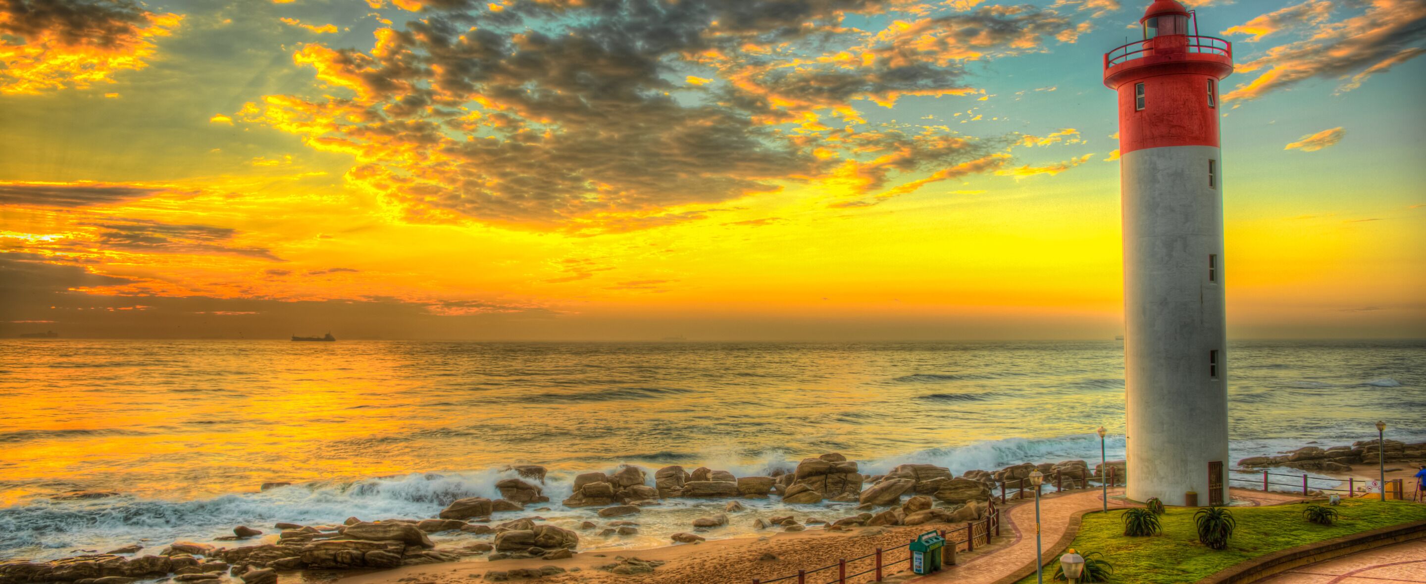 Um farol à beira-mar ao pôr do sol.