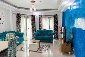 Apartamento luxo, 3 quartos | Área de estar | TV de tela plana 32 polegadas com canais via satélite, TV