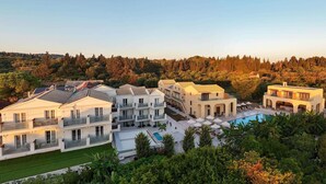 Resort com várias villas, piscina e paisagem arborizada.