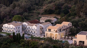 Um bairro residencial com vários edifícios brancos, uma piscina e um jardim bem cuidado.