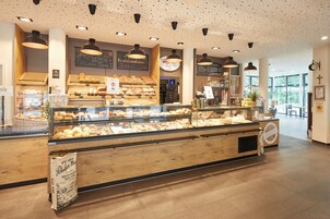 Vitrine de uma padaria com diversos produtos de panificação e um letreiro indicando uma marca com 450 anos.