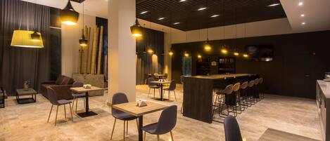 Um interior de restaurante moderno com piso de mármore, mobiliário contemporâneo e iluminação ambiente.
