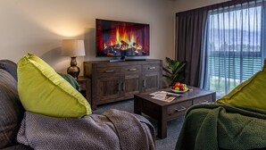 Uma sala de estar moderna com lareira, televisão e uma mesa de jantar com frutas.