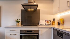 Uma cozinha moderna com forno embutido, lava-louças e exaustor de aço inoxidável.