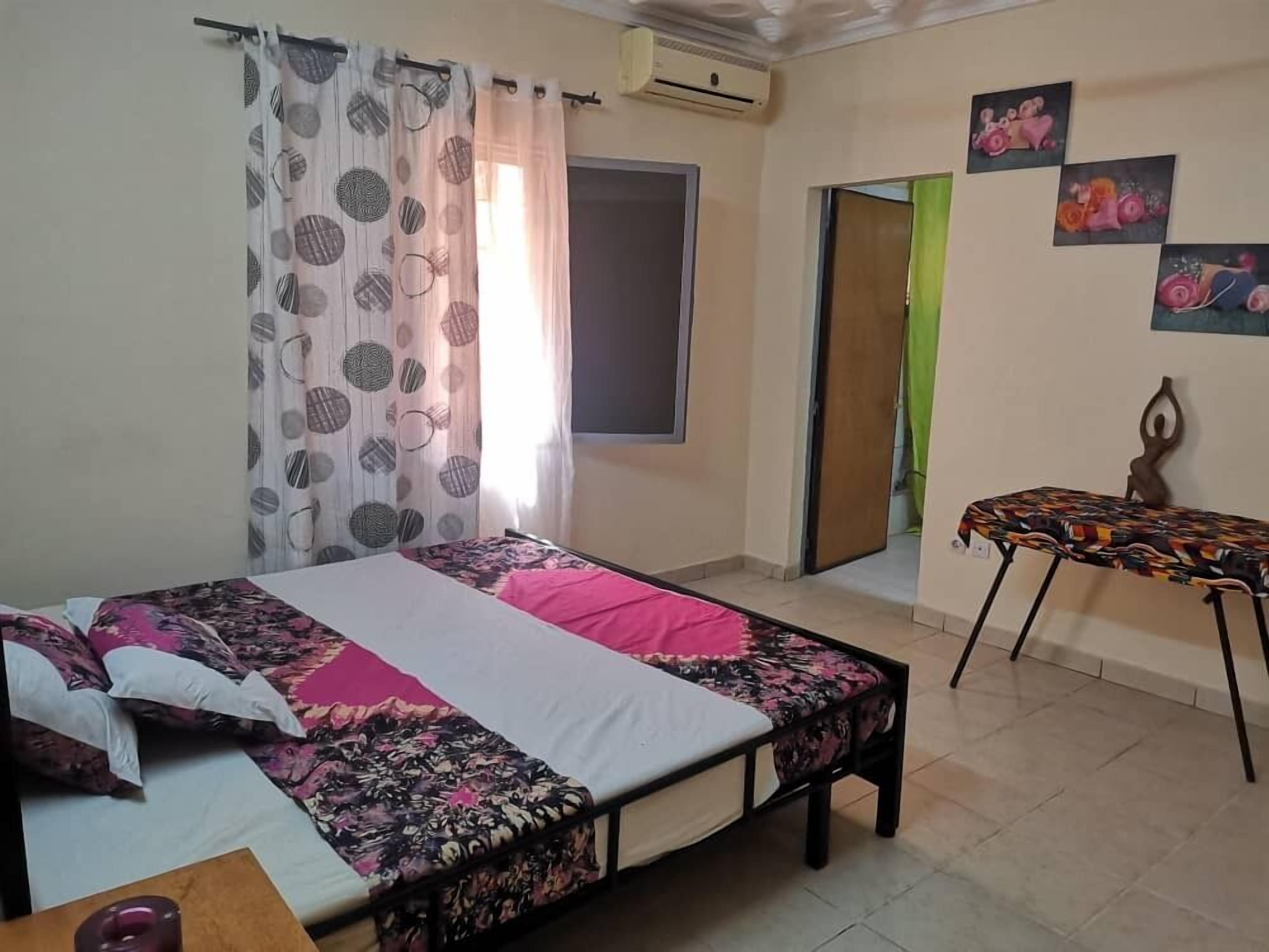 Um quarto com cama, mesa e cadeira.