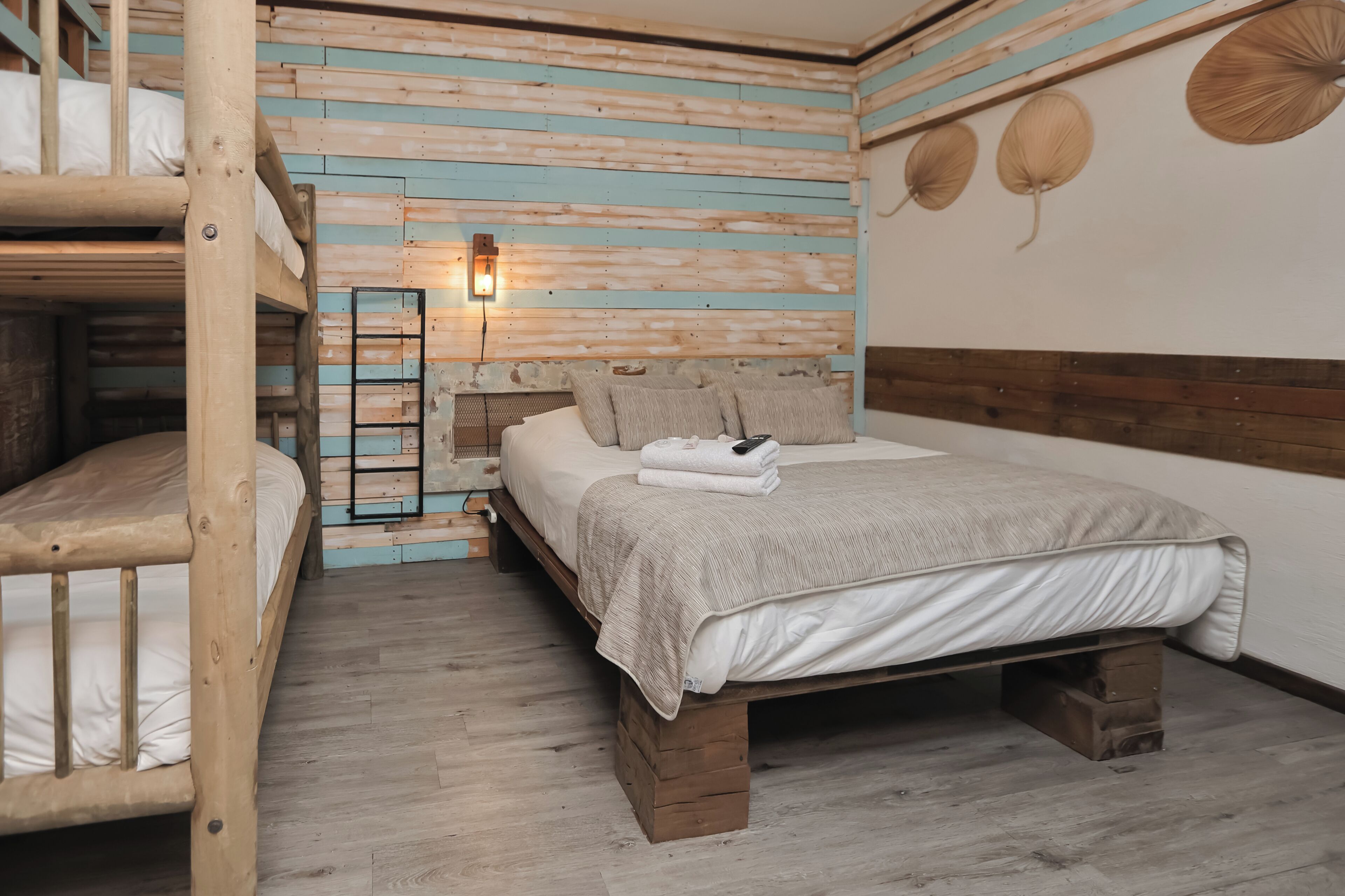 Um quarto com uma cama de solteiro, uma cama individual, paredes de madeira e uma prateleira fixada na parede.