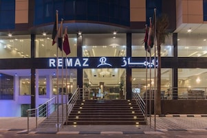 Entrada de hotel com design moderno, apresentando uma escadaria que leva ao saguão.