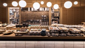 Disposição de buffet com diversos alimentos e utensílios.