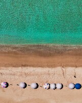 Uma praia com uma fileira de guarda-sóis e uma vista ampla do oceano.