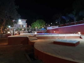 Área externa com uma fonte, degraus e um edifício ao fundo.