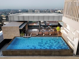 Piscina no terraço com vista para a paisagem urbana.
