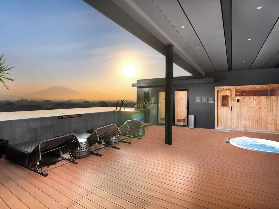 Terraço no terraço com deck de madeira, área de estar e banheira de hidromassagem.