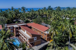 Um hotel com vários edifícios, piscina e vista para o mar.