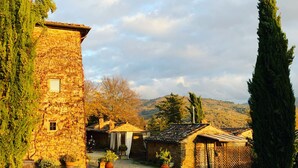 Um edifício de pedra com um caminho de cascalho que leva a um alpendre coberto.