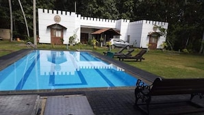Uma piscina com uma estrutura que lembra um castelo ao fundo.