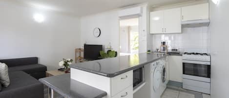 Apartamento Deluxe, 1 quarto | Cozinha privada | Um frigorífico, um micro-ondas, um forno, uma placa de cozinha