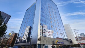 Um hotel alto e moderno com fachada de vidro, situado em área urbana.