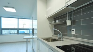 Uma cozinha moderna com uma janela ampla, pia de aço inoxidável e fogão embutido.