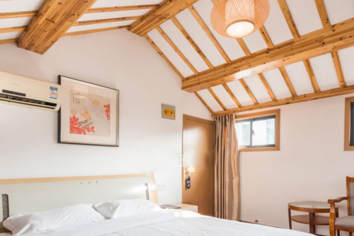 Quarto com cama, escrivaninha e cadeira.