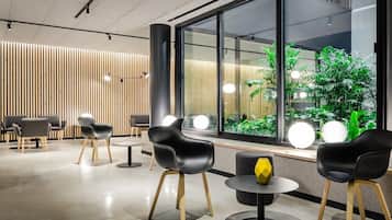 Interior moderno com área de estar, uma janela ampla com vista para o verde e um objeto decorativo amarelo sobre uma mesa.