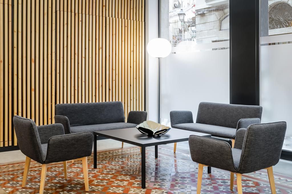 Interior moderno com parede de ripas de madeira, piso com padrão geométrico e mesa com quatro cadeiras cinzas.
