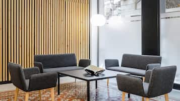 Interior moderno com parede de ripas de madeira, piso com padrão geométrico e mesa com quatro cadeiras cinzas.