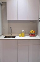 Um micro-ondas no espaço comum, utensílios de cozinha 