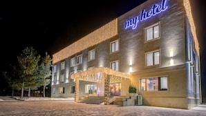 Um hotel com fachada moderna, entrada coberta e uma placa com a inscrição "my hotel".