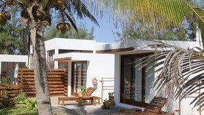 Uma casa moderna com área de varanda, móveis de madeira e uma palmeira.