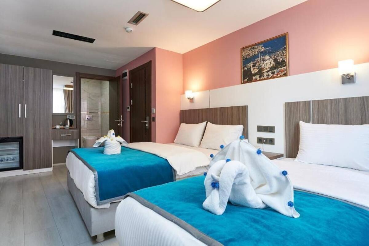 Quarto de hotel com duas camas, banheiro e vista para a cidade.