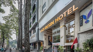 Entrada de hotel com uma placa que diz 'SAZI RESIN HOTEL'.
