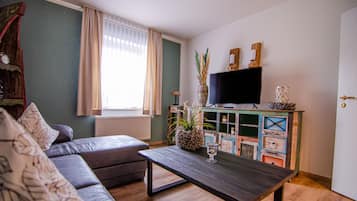 Apartamento, no piso térreo | Área de estar | TV de tela plana 80 cm com canais via satélite, TV