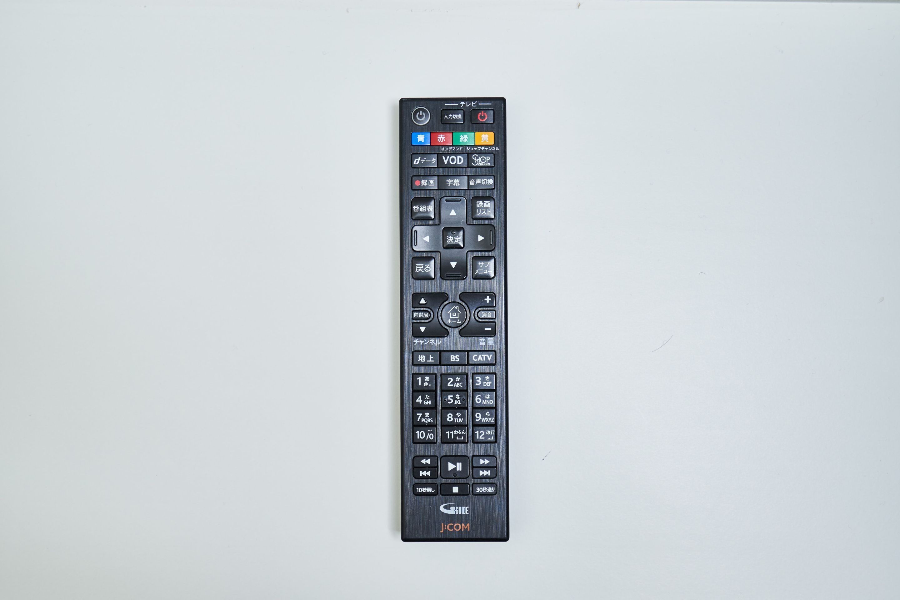 Um controle remoto preto com texto e símbolos em japonês.