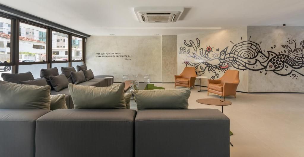 Uma área de estar moderna com sofá, cadeiras e um mural na parede.