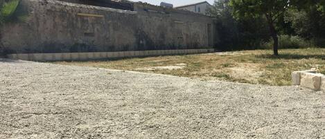 Um edifício com fachada rústica e chão de brita.