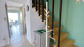 Um interior moderno com uma escada, um pequeno espaço de armazenamento e um tapete quadriculado.
