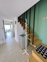 Um interior moderno com uma escada, um pequeno espaço de armazenamento e um tapete quadriculado.