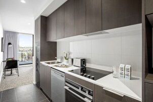 Uma cafeteira/bule, Minifrigorífico, uma placa de cozinha 