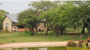 Uma casa com um quintal cercado e um lago.