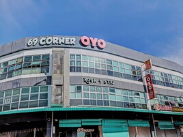 Um edifício com sinalização indicando "69 CORNER OYO" e "ROOM 4 STAY".
