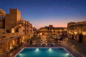 Um edifício histórico com piscina, vários níveis e um pátio.