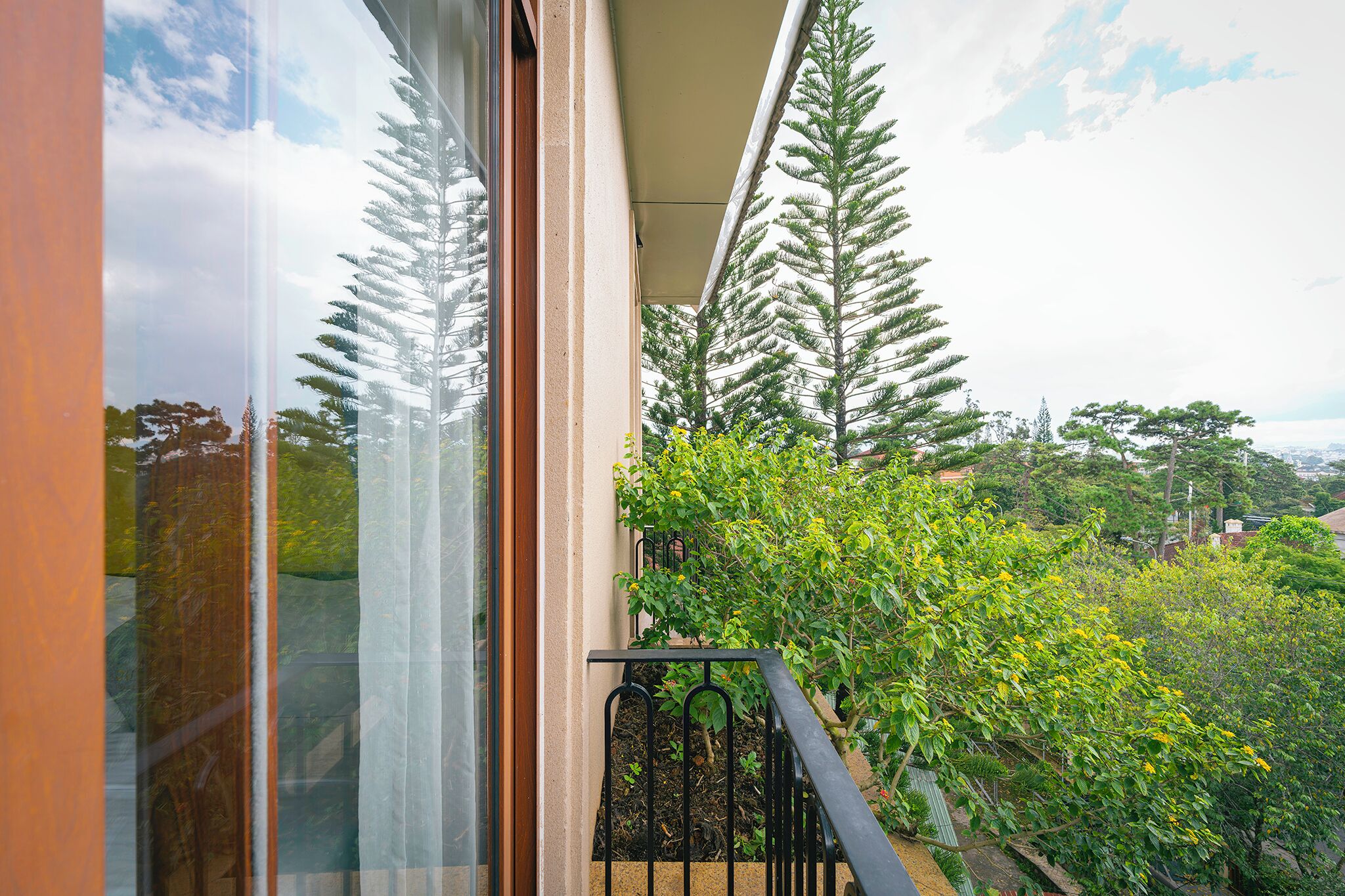 Varanda com vista para um jardim e árvores.