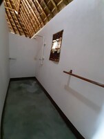 Um polibã, um chuveiro fixo, chinelos, um bidé 