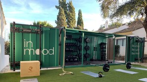 Um contentor verde com a inscrição 'in mood', contendo equipamentos de musculação.