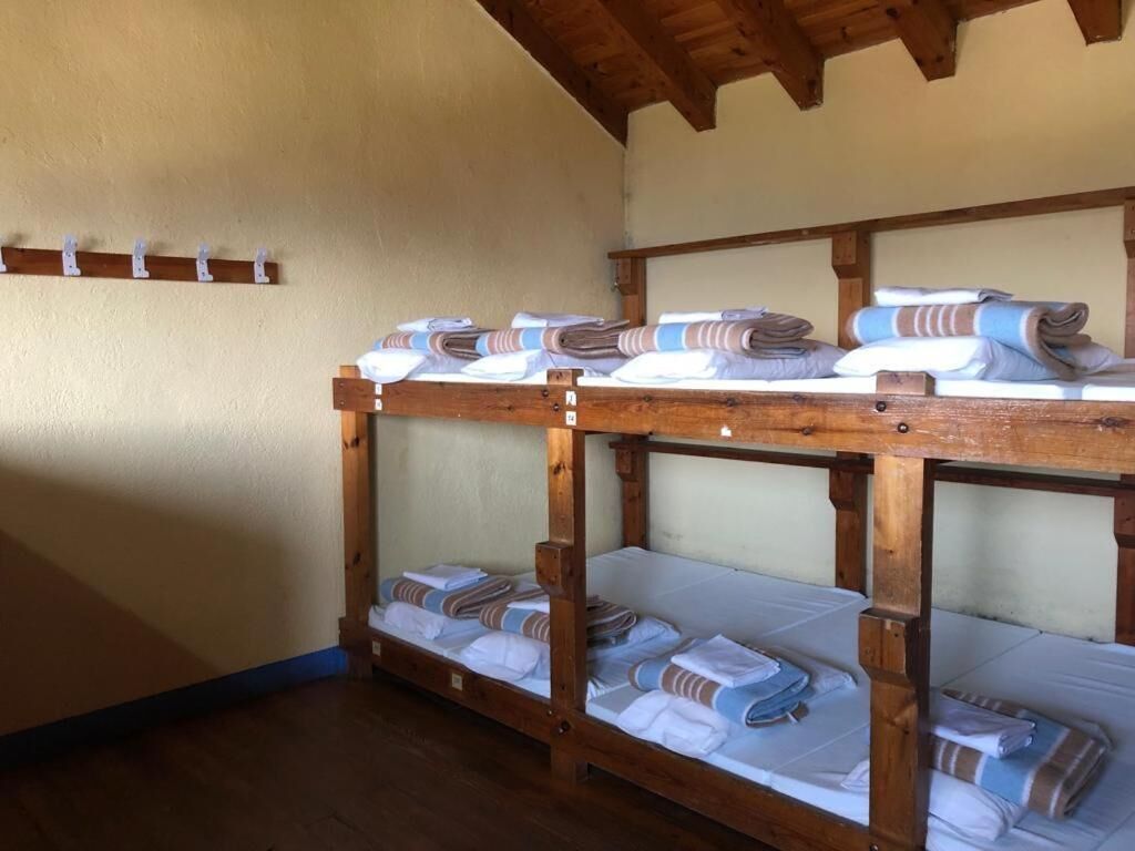 Beliches com toalhas e teto de madeira.
